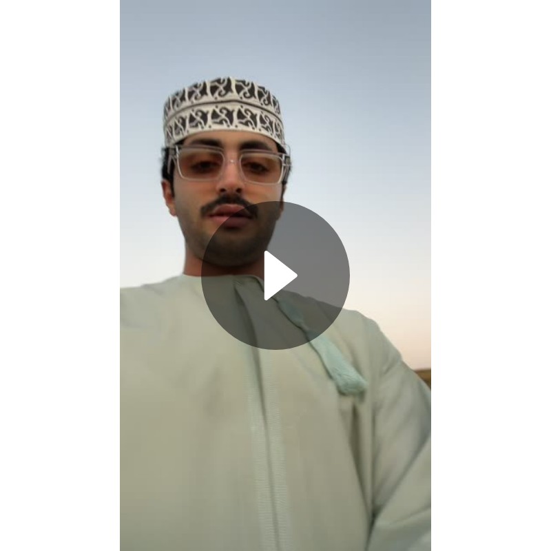 Man wearing traditional Omani kuma hat demonstrates cultural attire ...